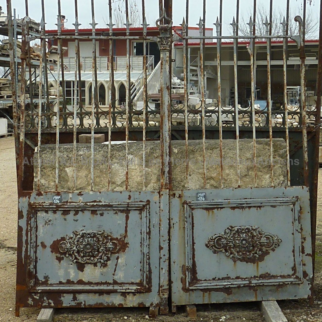 Antique riveted wrought-iron gate with two semi-openwork doors.