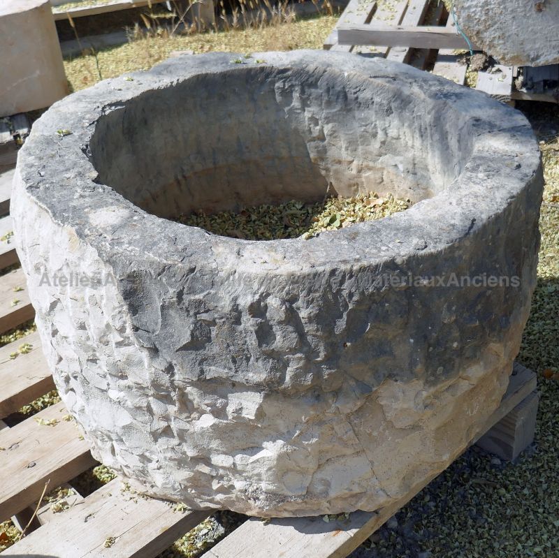 Antique round hard-stone trough as an ecological sturdy stone planter