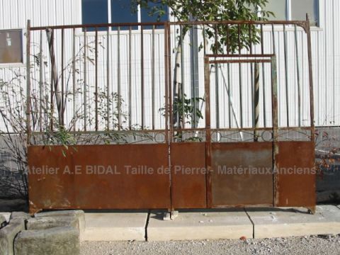 Wide antique wrought-iron gate with wicket-gate.